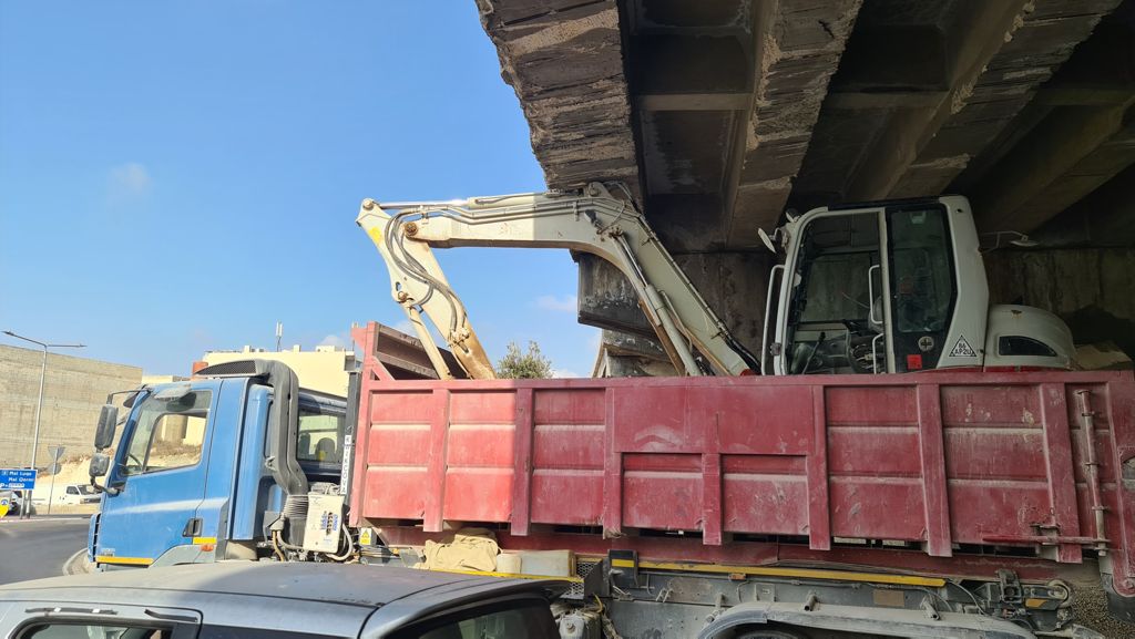 Traffic jam caused by truck carrying an excavator which got stuck under ...